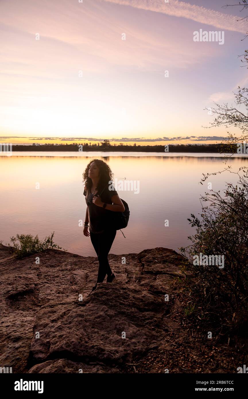 Traveler woman walking by the lake during sunset Stock Photo - Alamy