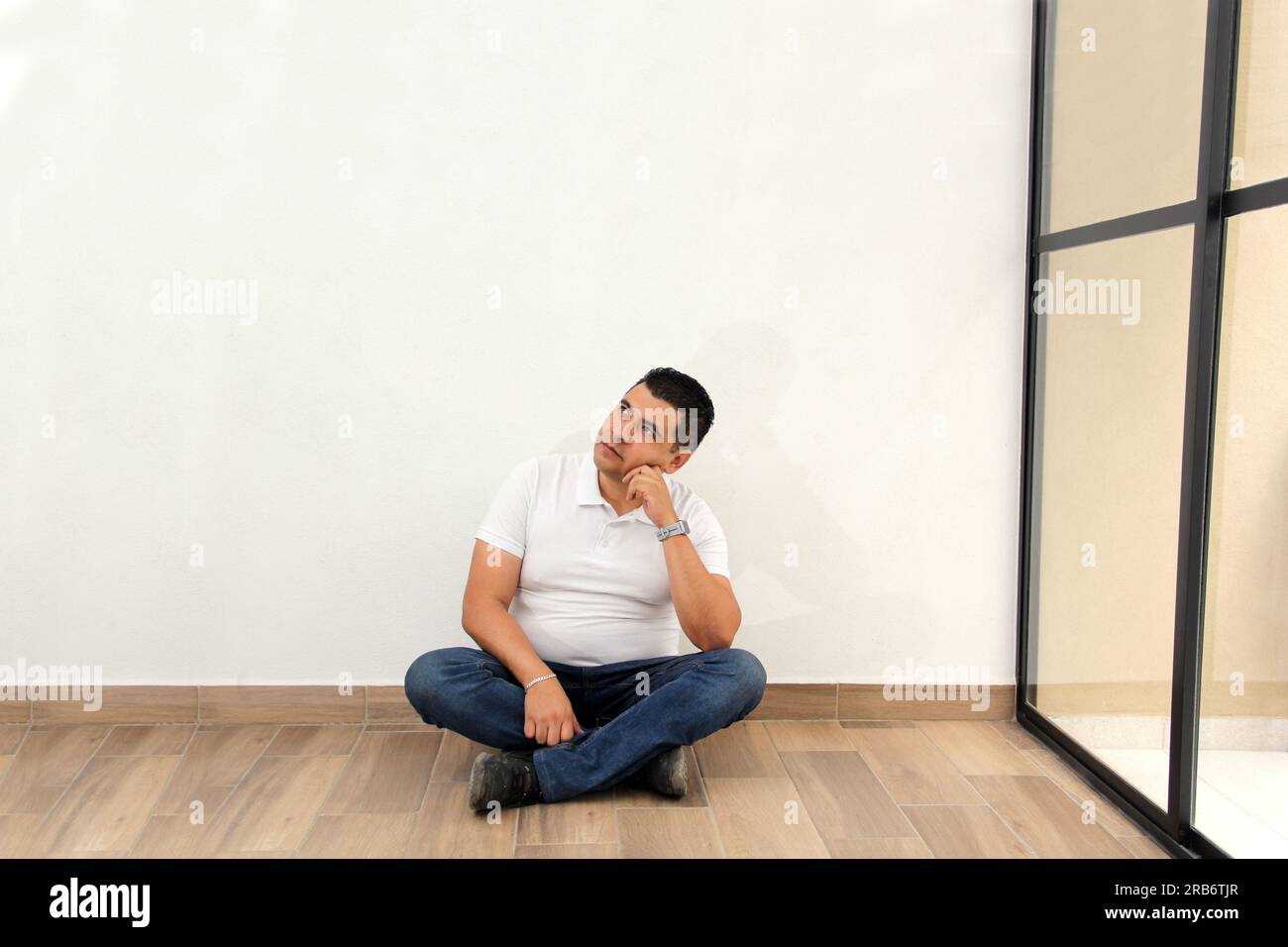 Dark-haired 40-year-old Latino man is happy and excited to open his new house, still empty Stock ...