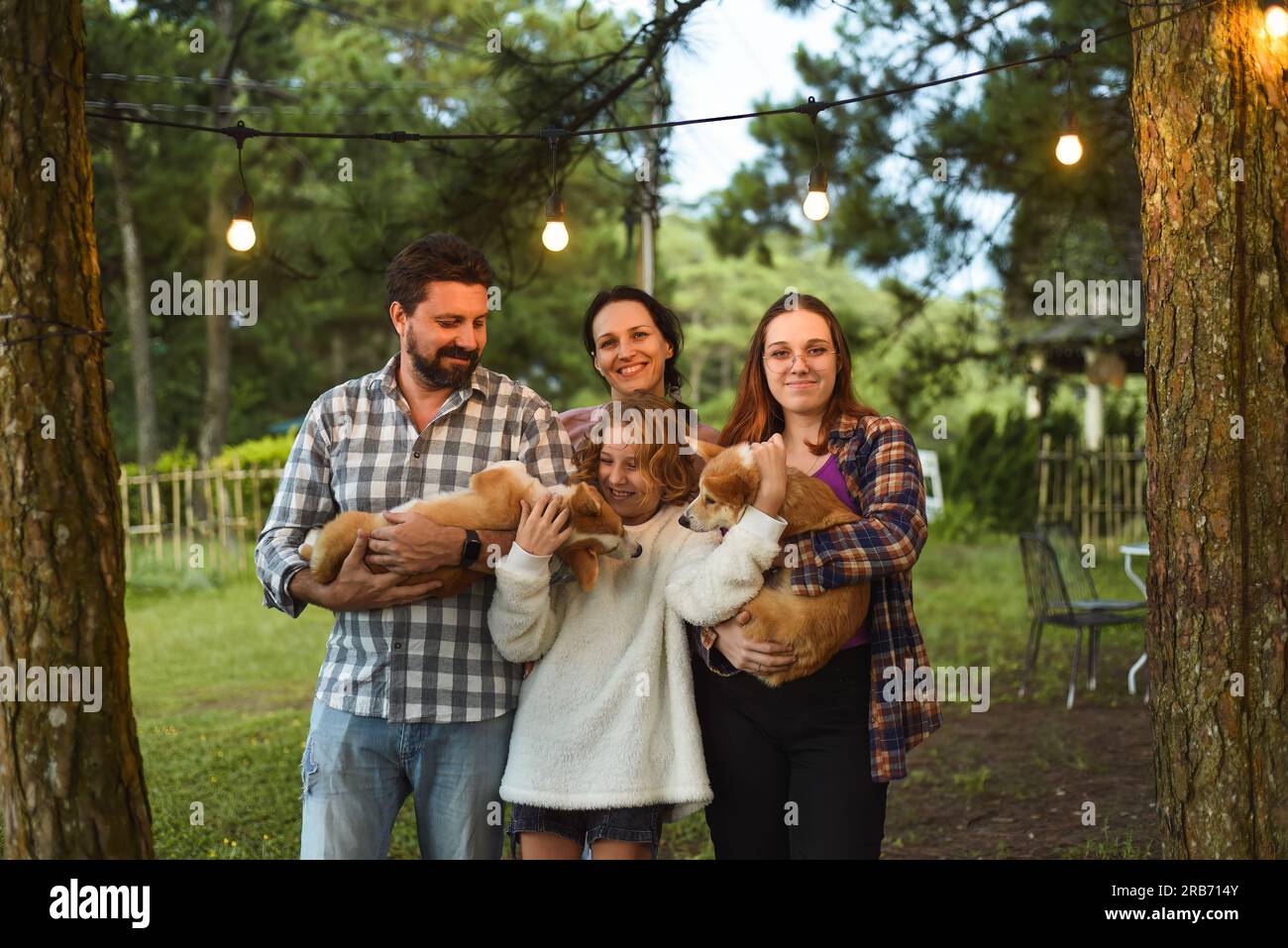Family members father, mother and two daughters with corgi dogs in the forest Stock Photo - Alamy