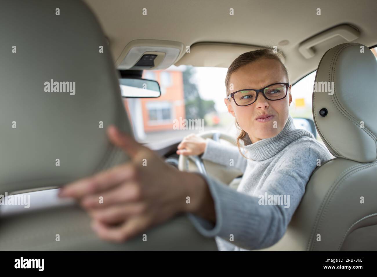 Woman driving a car - female driver at a wheel of a modern car, looking ...