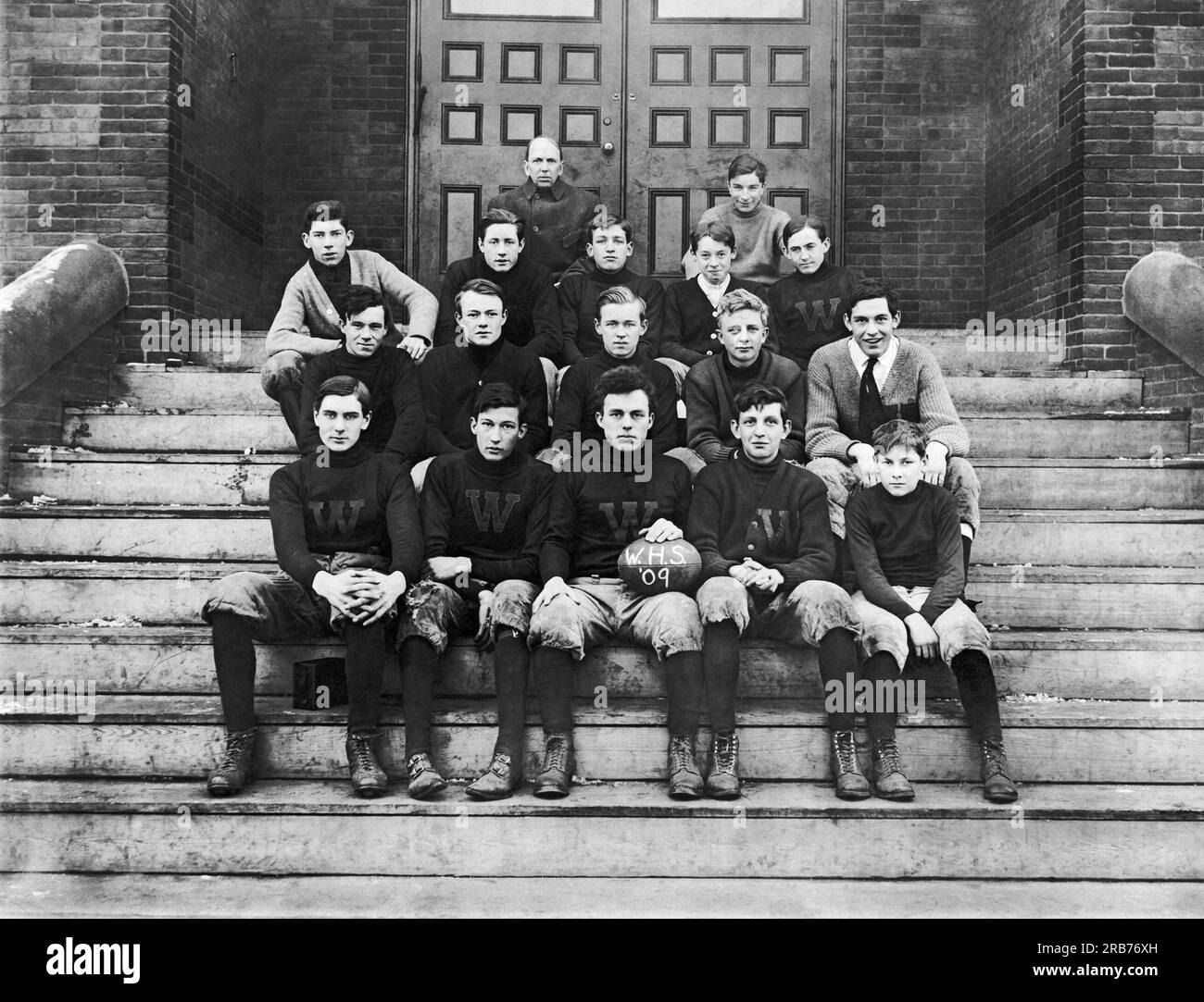 United States: 1909 A portrait of a high school football team sitting ...
