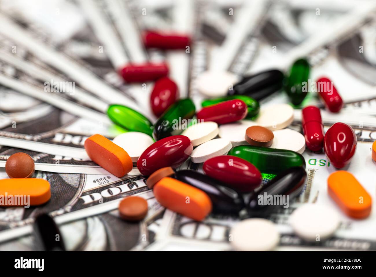 A close-up photo of colorful pills and a top on a 10-dollar bill in a ...