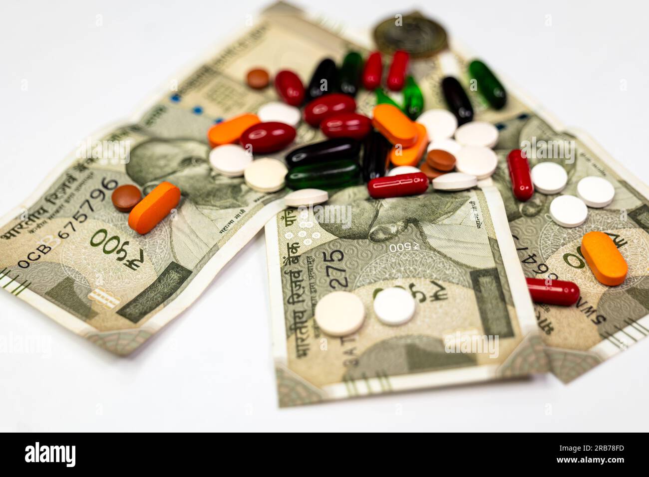 A photo of Indian 500 rupees banknote with colorful pills on top and a ...