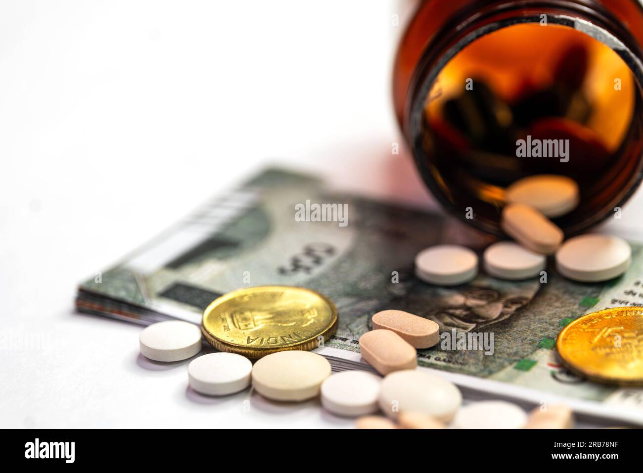 This image is about Pills and bottle on the floor with Indian rupees ...