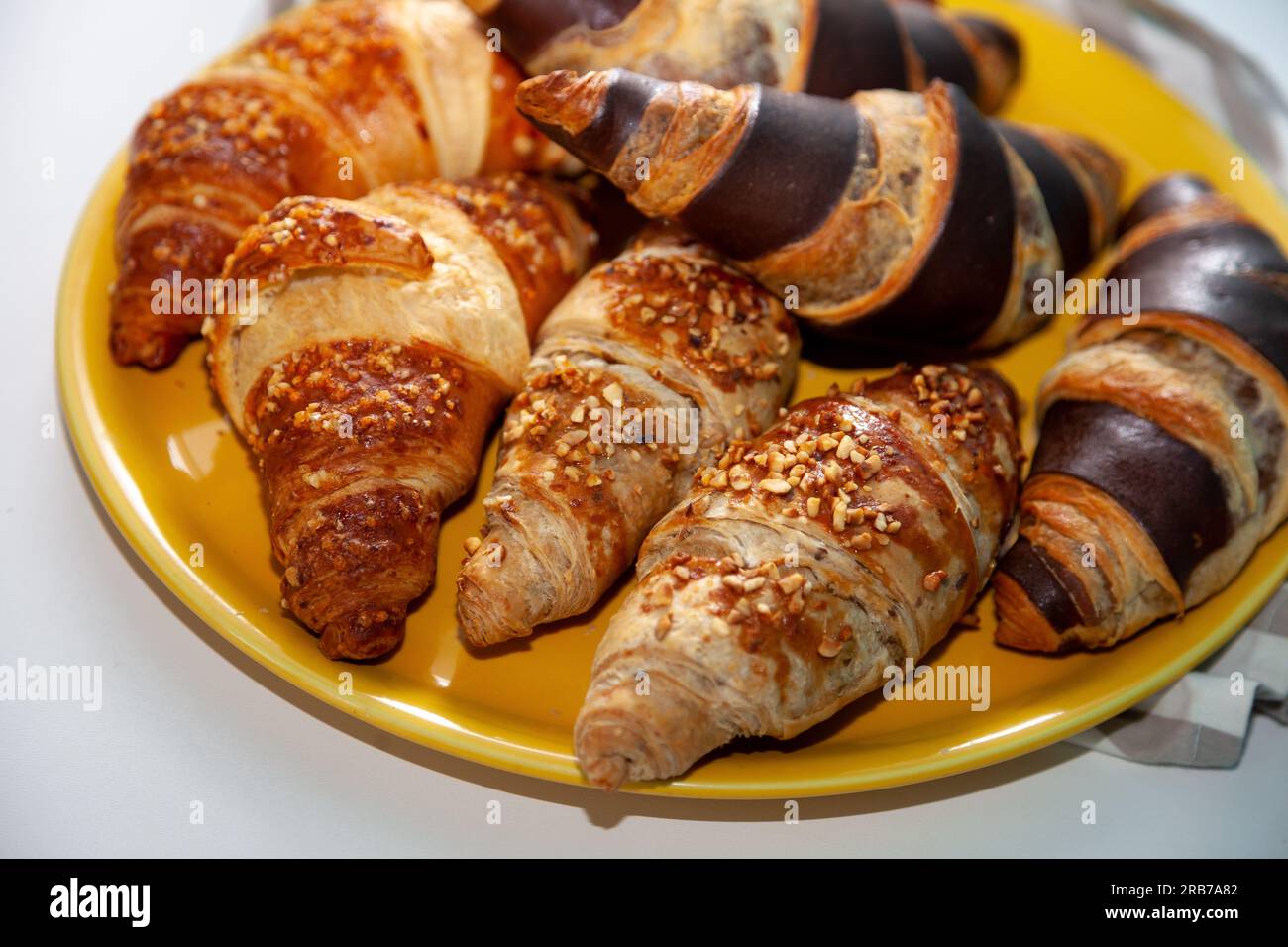 Chocolate croissants or croissant with nut crumbs on a plate. Delicious ...