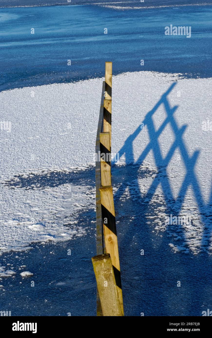 Long Wooden fence shadows being cast by the Winters sun at Murton Lochs ...