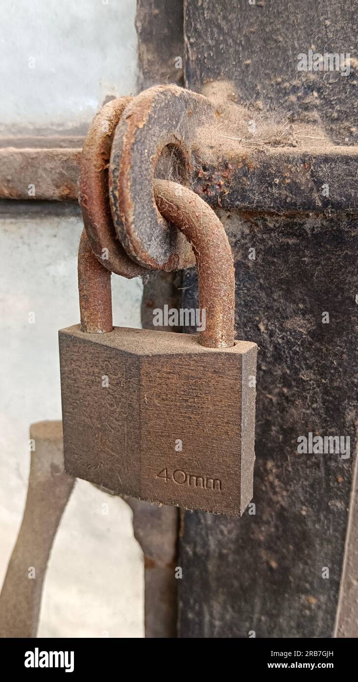 A weathered lock, still in use despite the rust, guarding with enduring ...