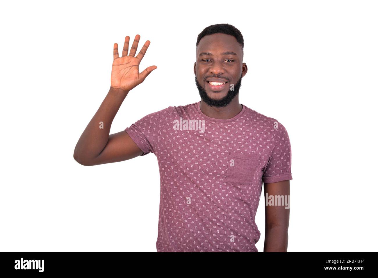 portrait of a handsome young man raising his hand while smiling at the ...