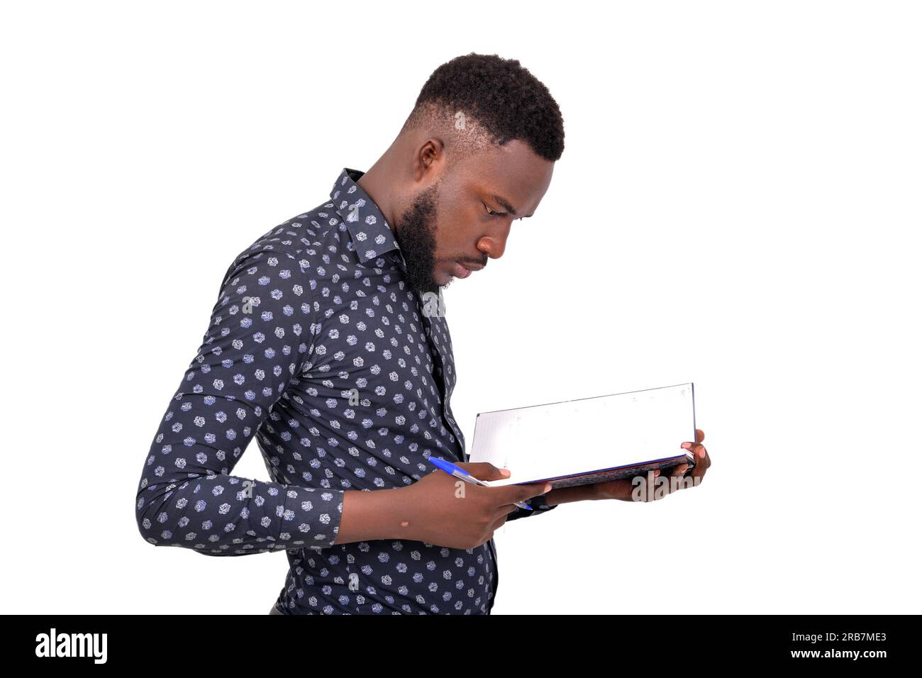 portrait of a serious young businessman checking notes on document ...