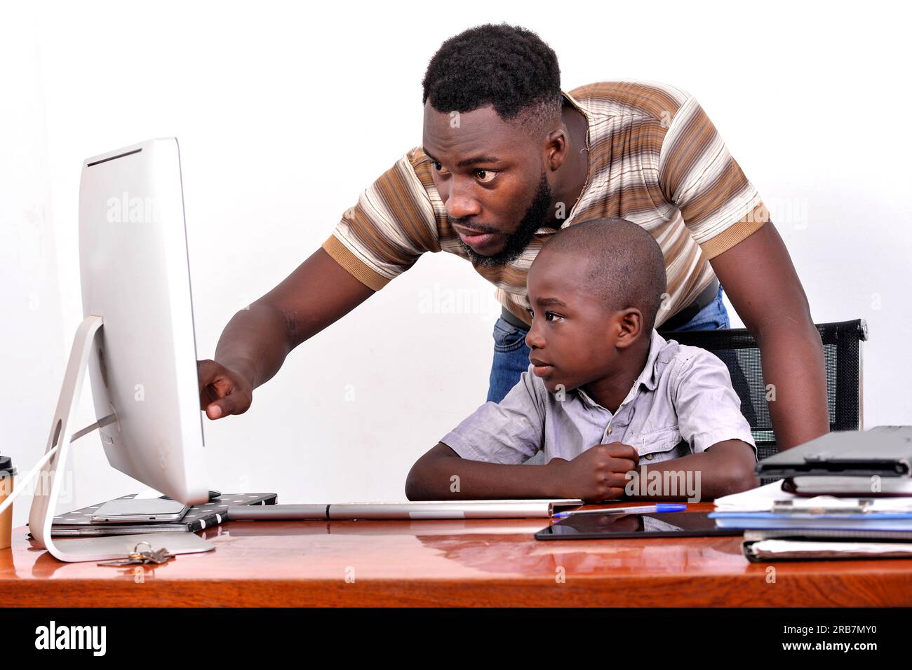 portrait of a young father teaching his little boy to use a laptop ...