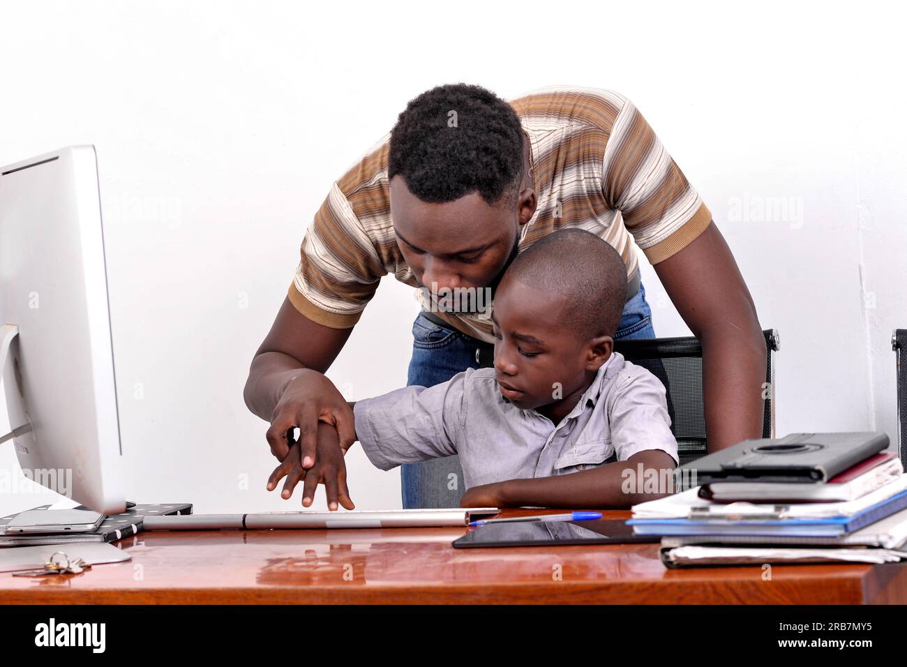 portrait of a young father teaching his little boy to use a laptop ...