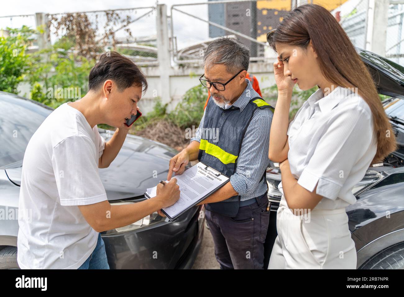 A car insurance agent showing the male customer where to sign the car ...