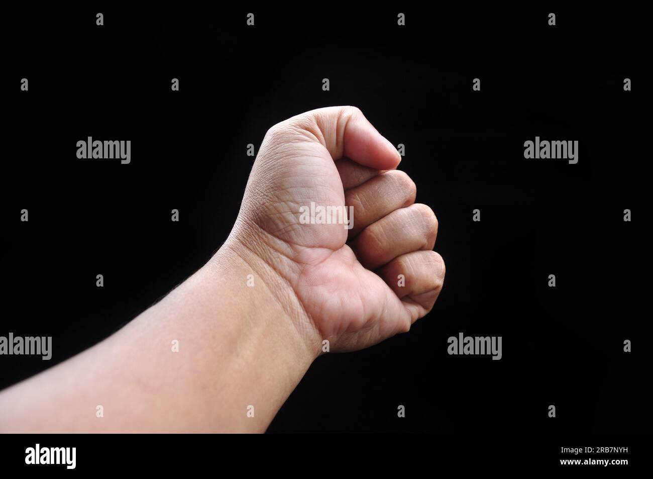 Selective focus photo of left hand clenched on black background Stock ...