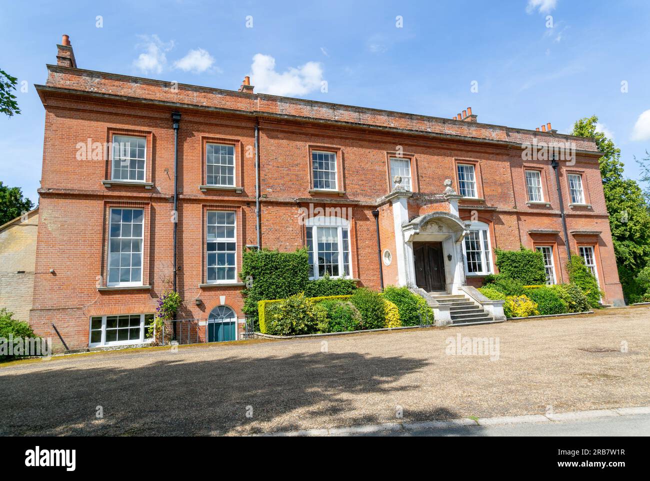 Red brick Georgian house, front facade of Redisham Hall gardens and ...