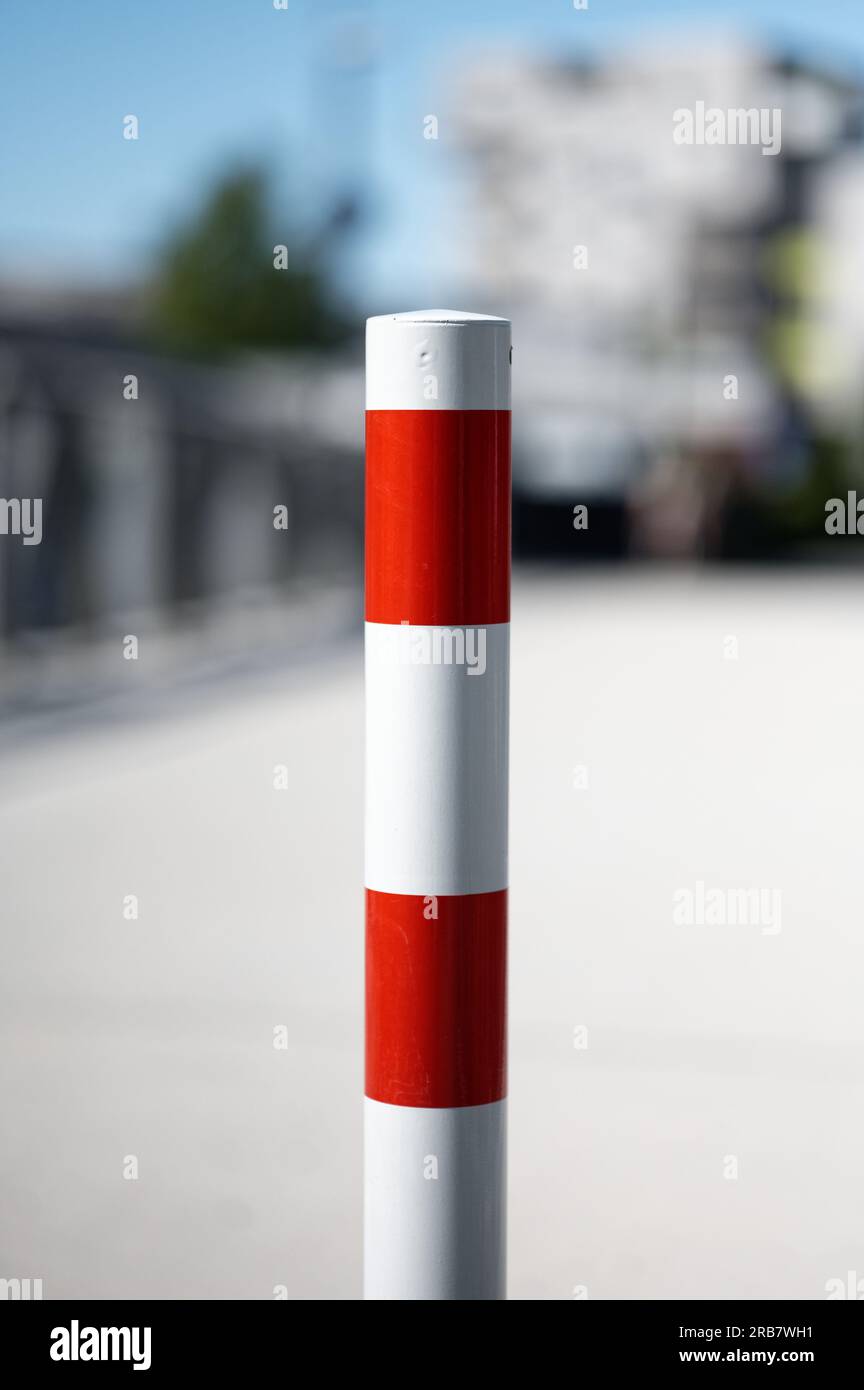 white red barrier post in front of path and bridge with buildings in ...