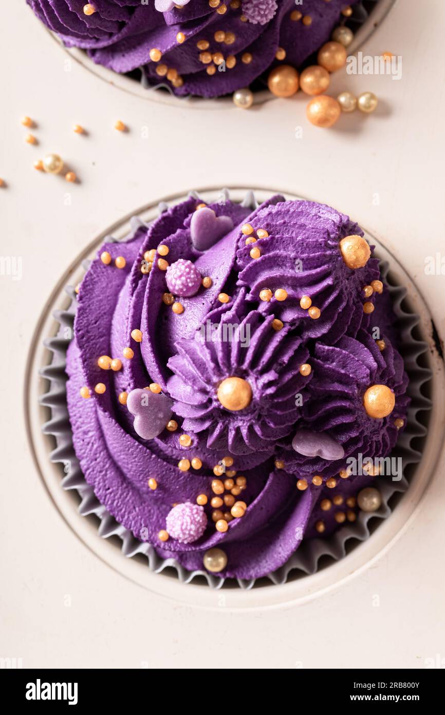 Beautiful and unique cupcakes ready to eat. Purple dessert with golden ...