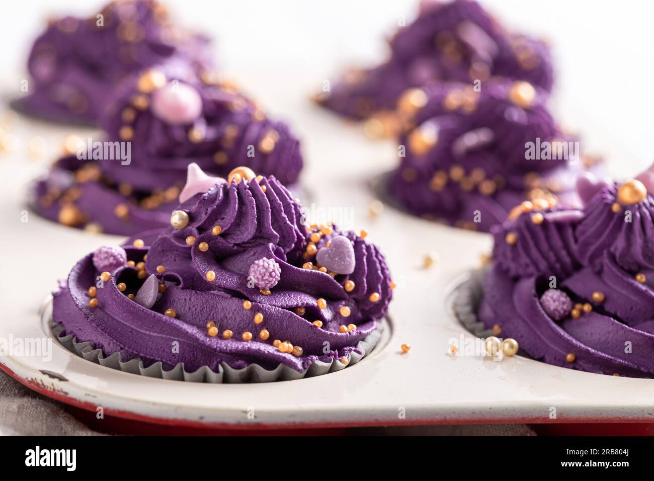 Sweet and tasty cupcakes with flower shaped cream. Purple dessert with ...