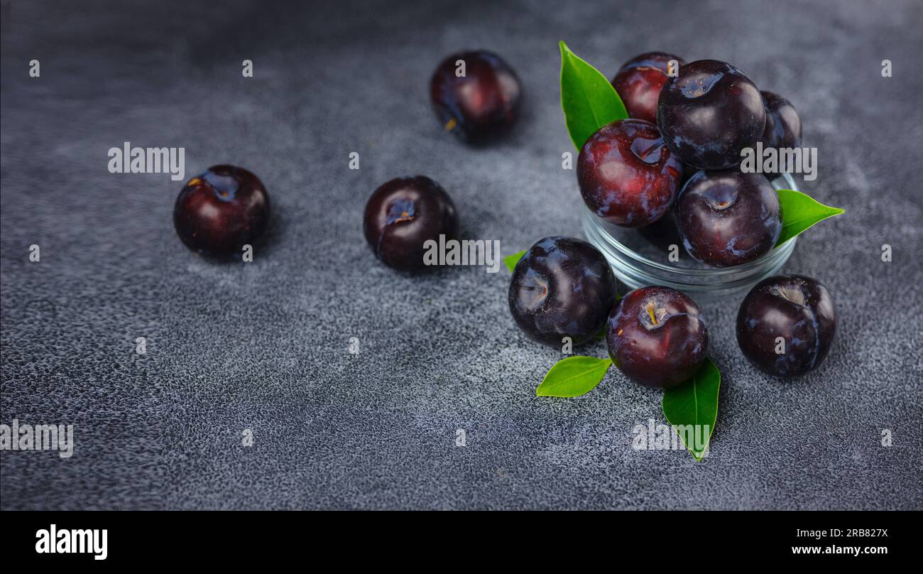 Sweet plums on dark background. Fresh blue plums with leaves. Food ...