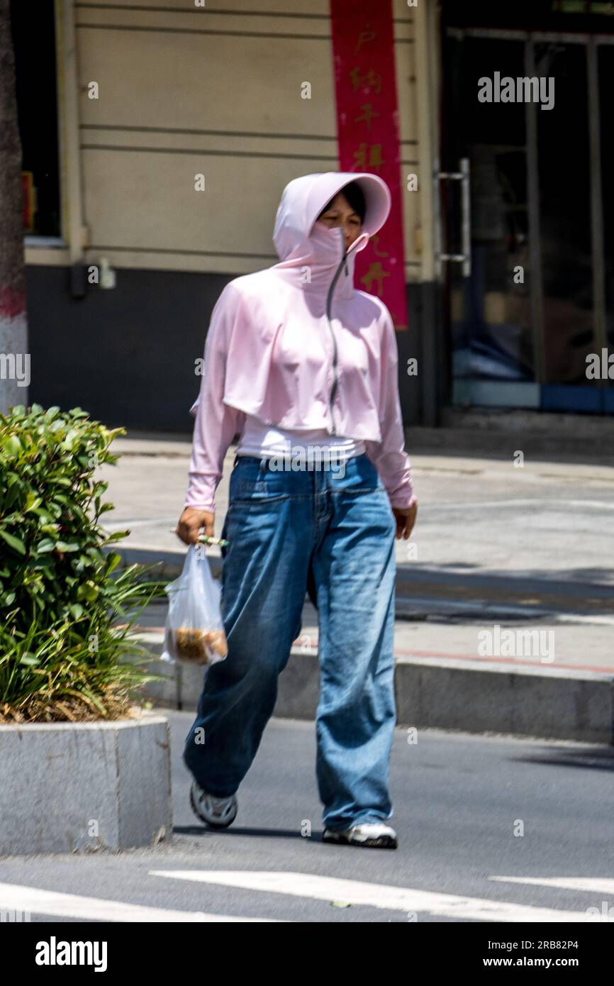 ANYANG, CHINA - JULY 8, 2023 - A pedestrian wearing protective clothing ...