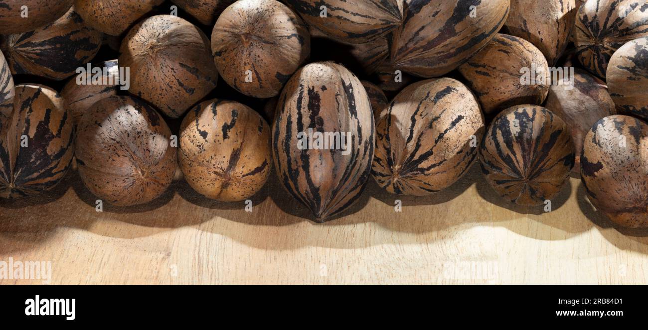 Pecans in their shells that are on a tan table Stock Photo - Alamy