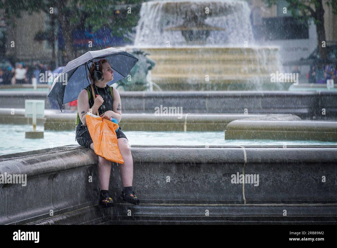 London, UK. 8th July 2023. UK Weather: Tourists and locals take cover ...