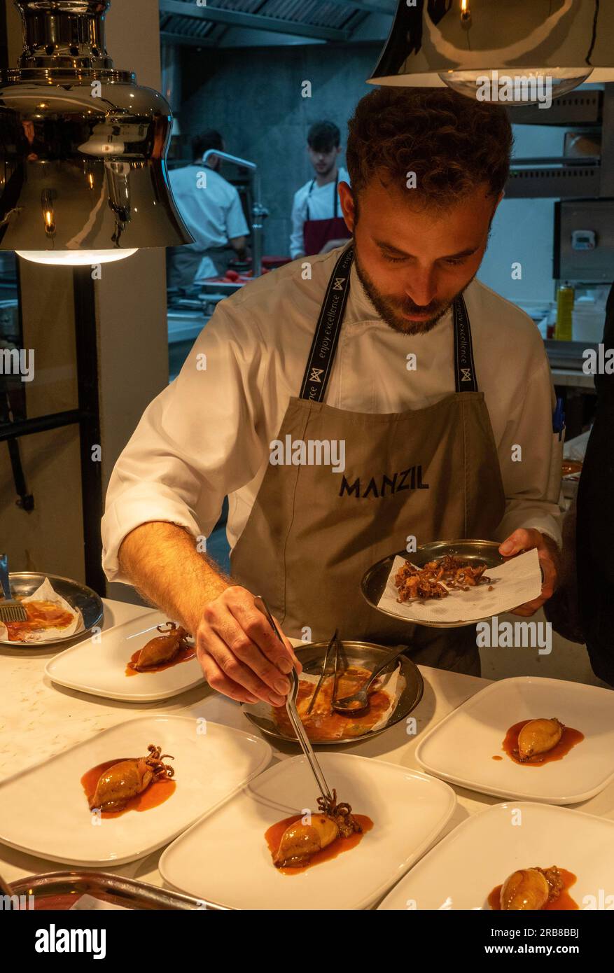 Prepairing the dish ' chipiron con menudo' - baby squid- at the fine ...