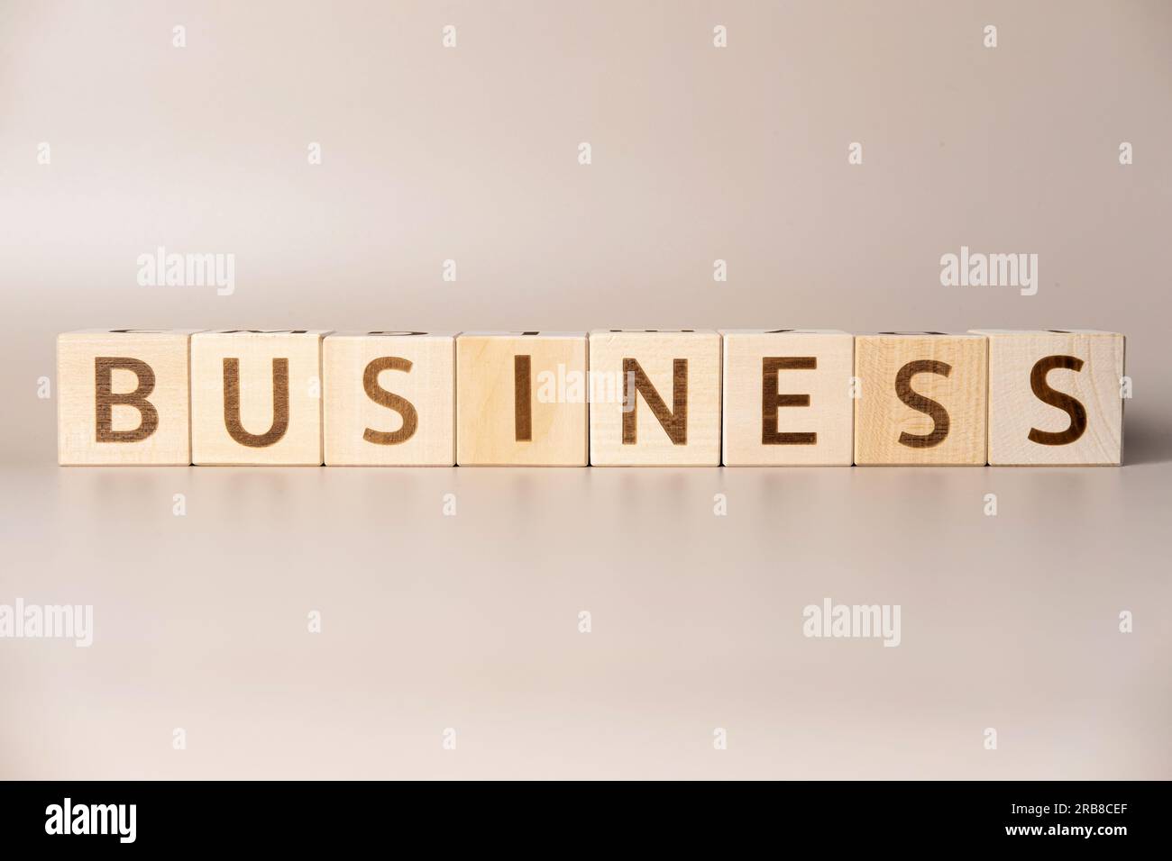 The word BUSINESS on wooden cubes on a beige neutral studio background ...