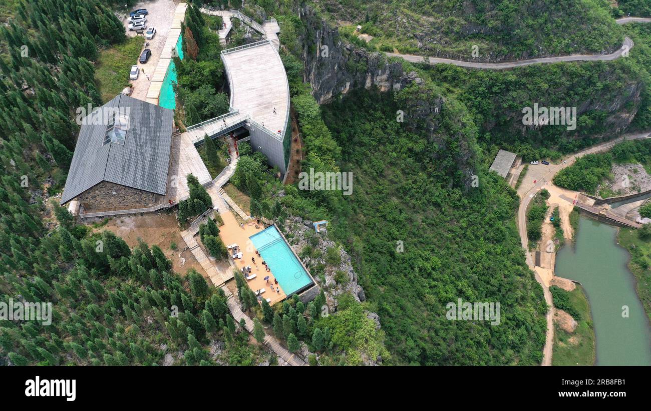 Tourists take a look at a cliff hotel in Lishu village, Dushan Township ...