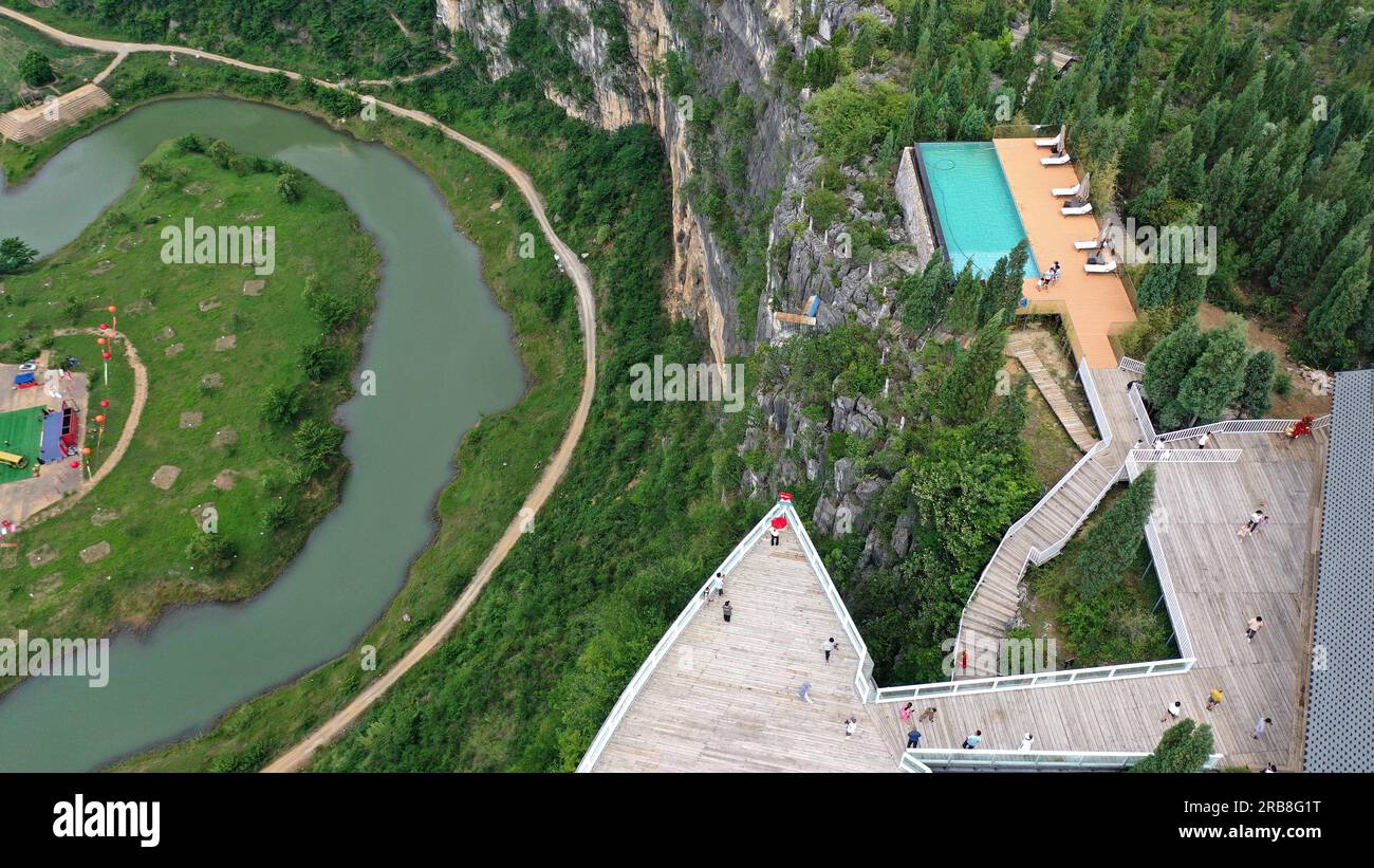 Tourists take a look at a cliff hotel in Lishu village, Dushan Township ...