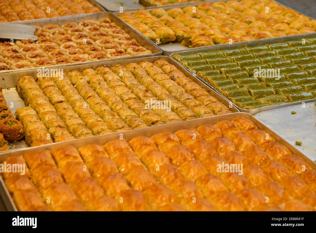 Mixed baklava varieties lined up on trays. Selective focus included ...