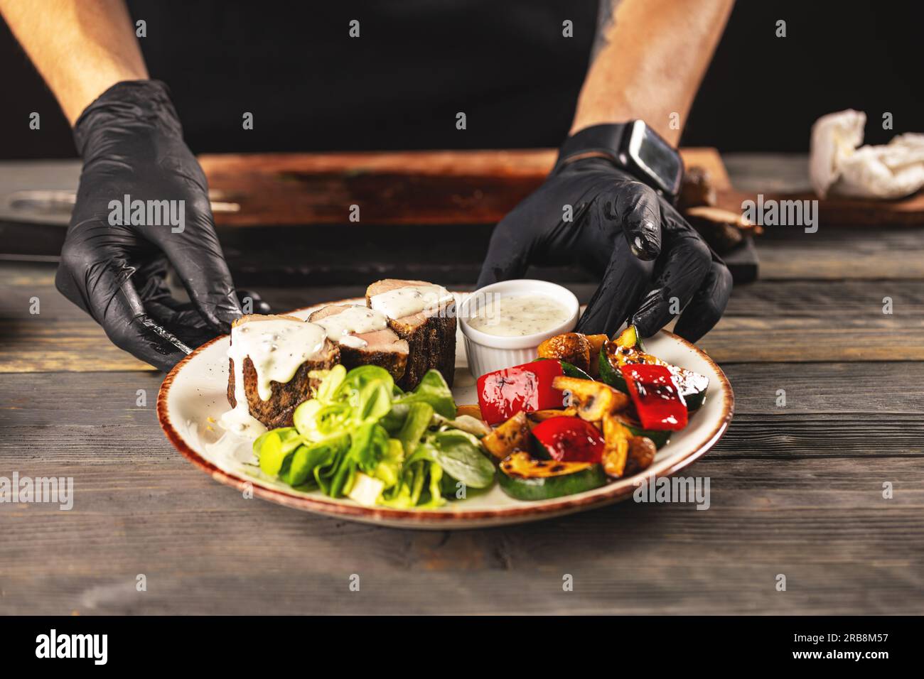 Chef finishing his plate and almost ready to serve at the table Stock ...
