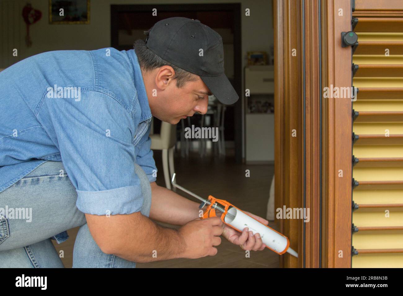 Image of a handyman who with a silicone gun closes the cracks in the ...