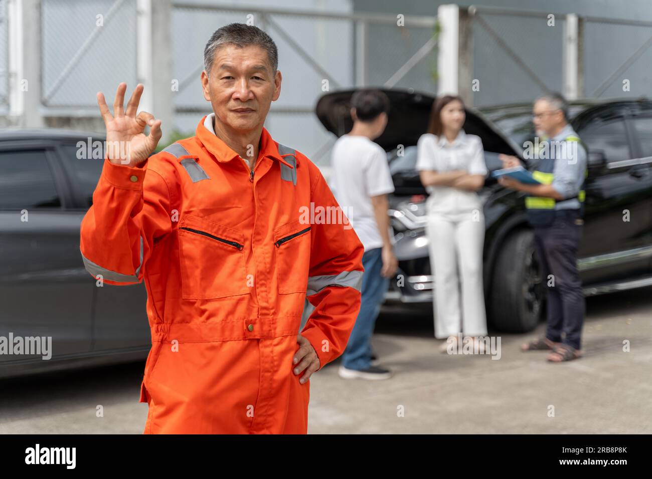 A male car insurance agent in orange jumpsuit standing proudly putting ...