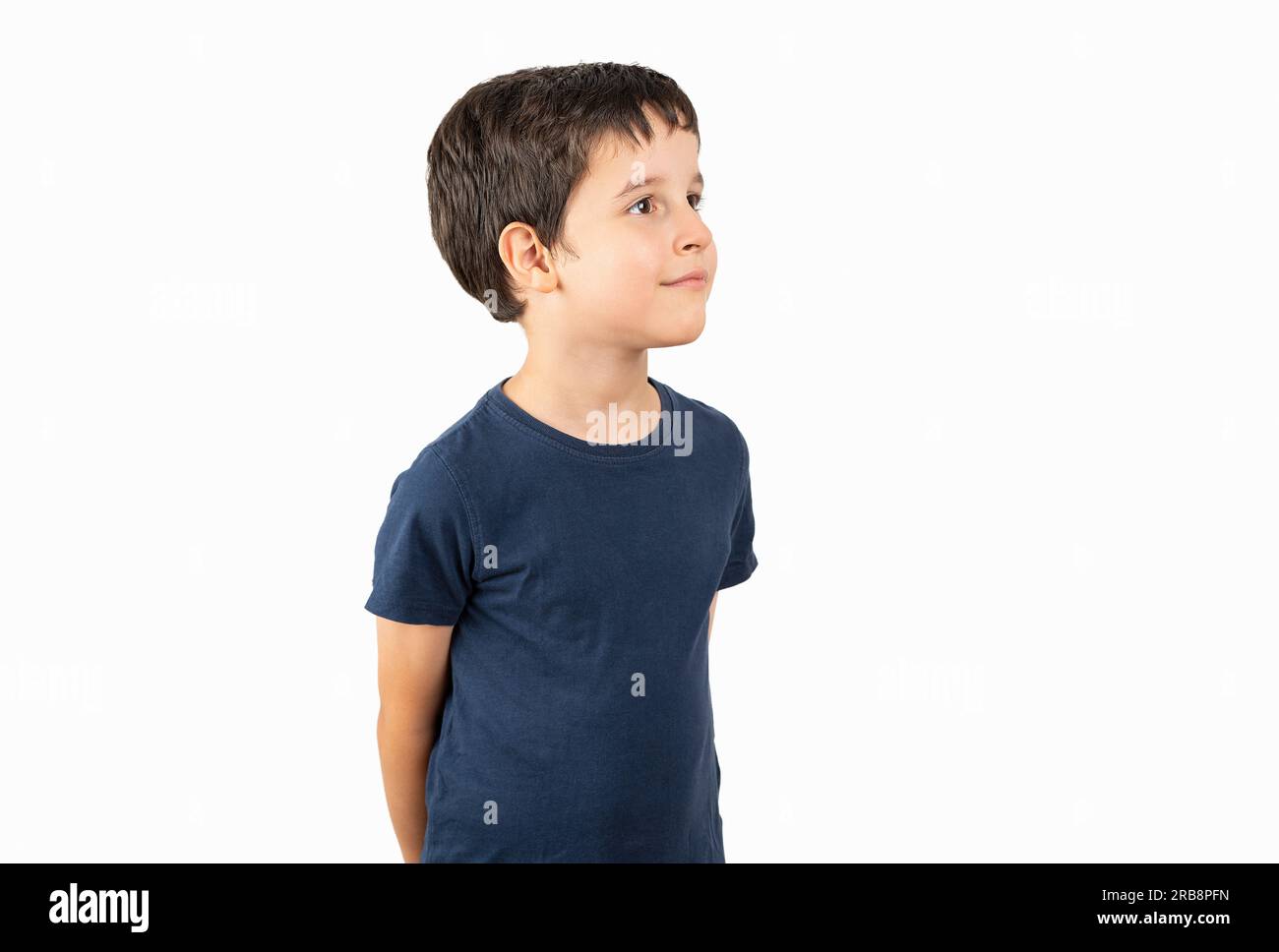 Child wearing casual t-shirt standing over white background looking ...