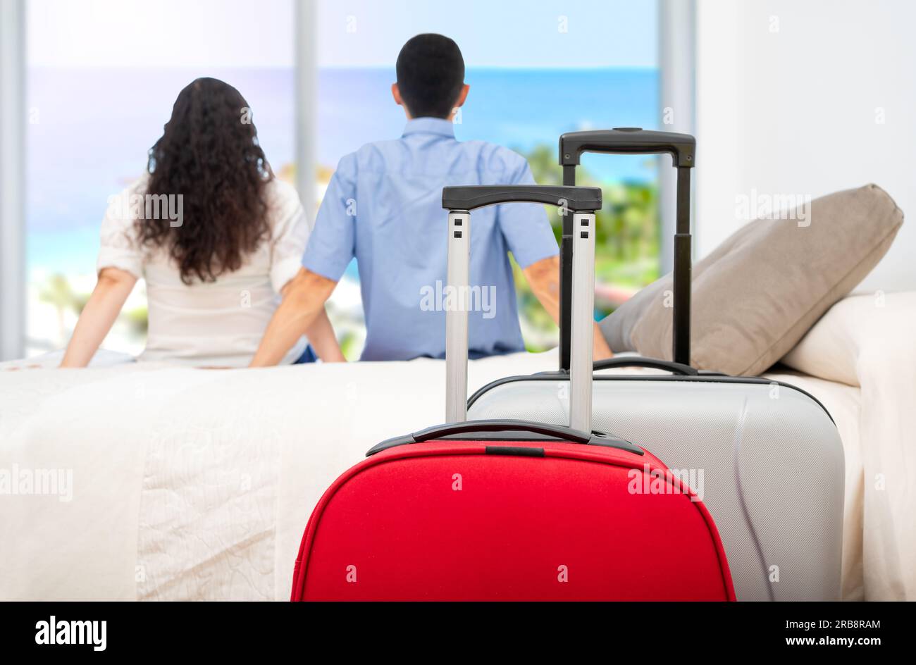 Back view of a couple of tourists relaxing looking through a window in ...