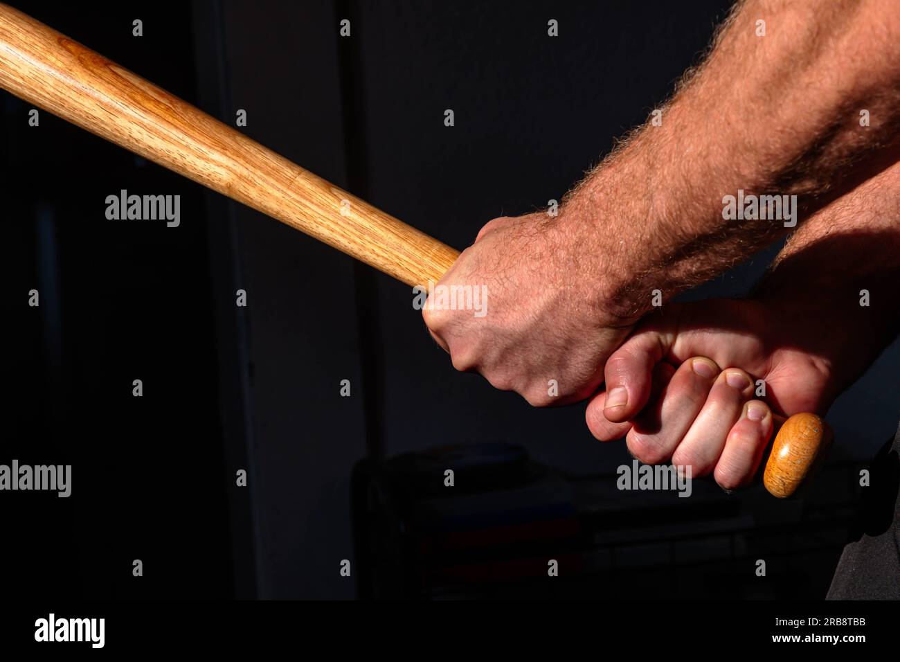 Abstract shot of close up baseball bad held in hand by a muscular man ...