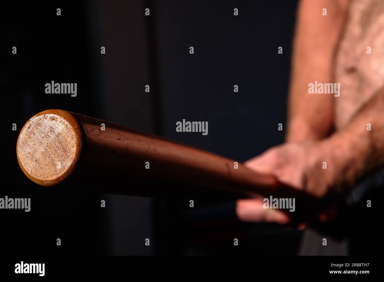 Abstract shot of close up baseball bad held in hand by a muscular man ...