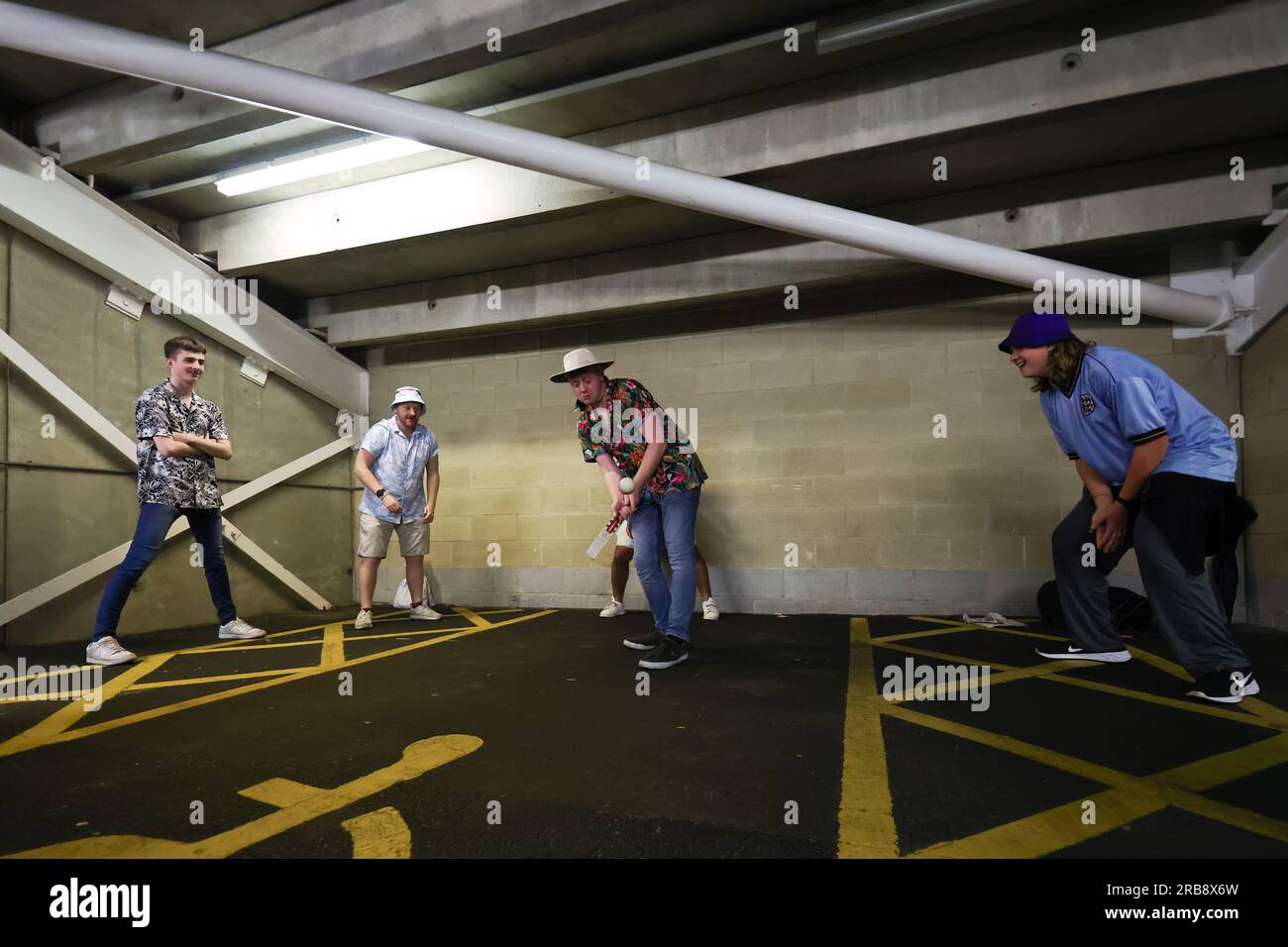 A group of people play cricket under the back of the stand during the ...