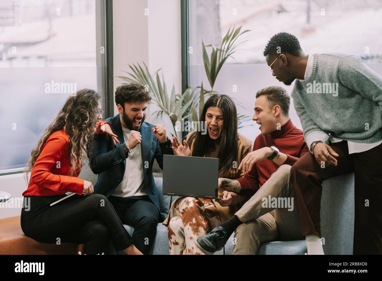 Diverse group of young programmers, sitting on a gray sofa at modern ... Diverse group of young programmers, sitting on a gray sofa at modern ...