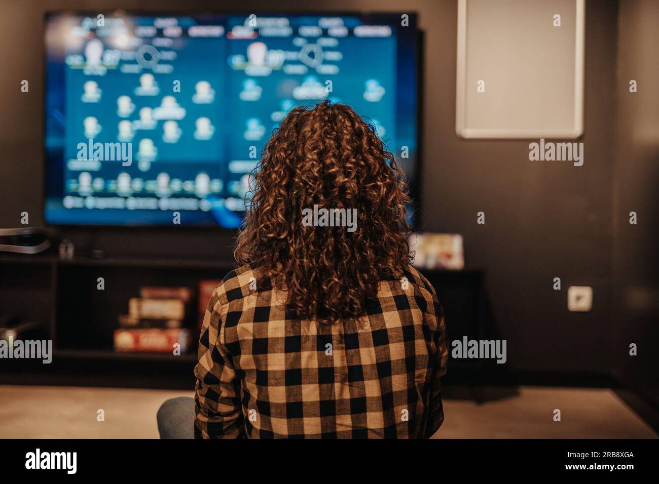 Young excited man sitting on sofa playing video games using remote ...