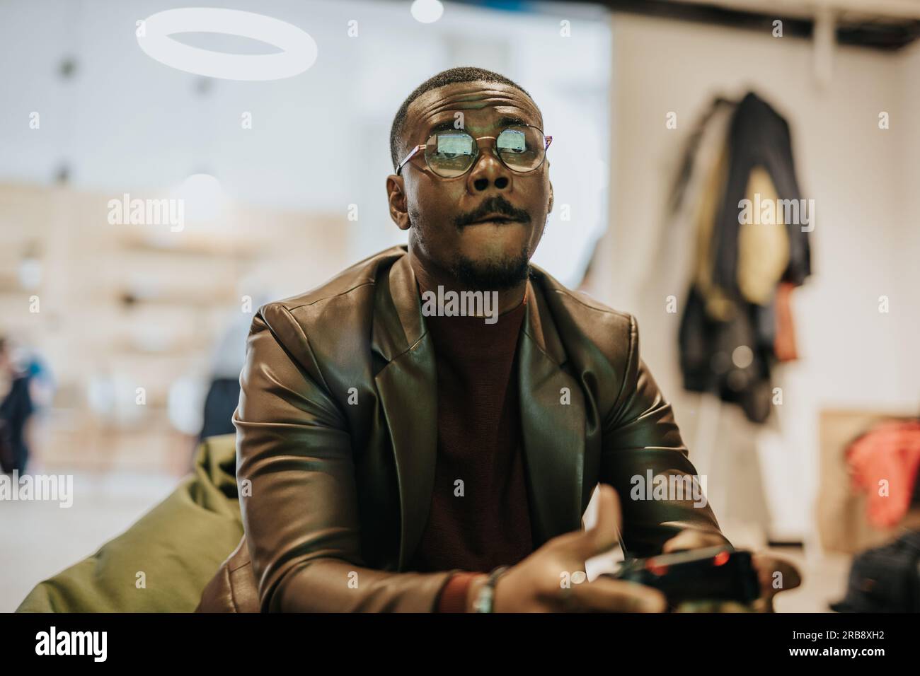 Young excited man sitting on sofa playing video games using remote ...