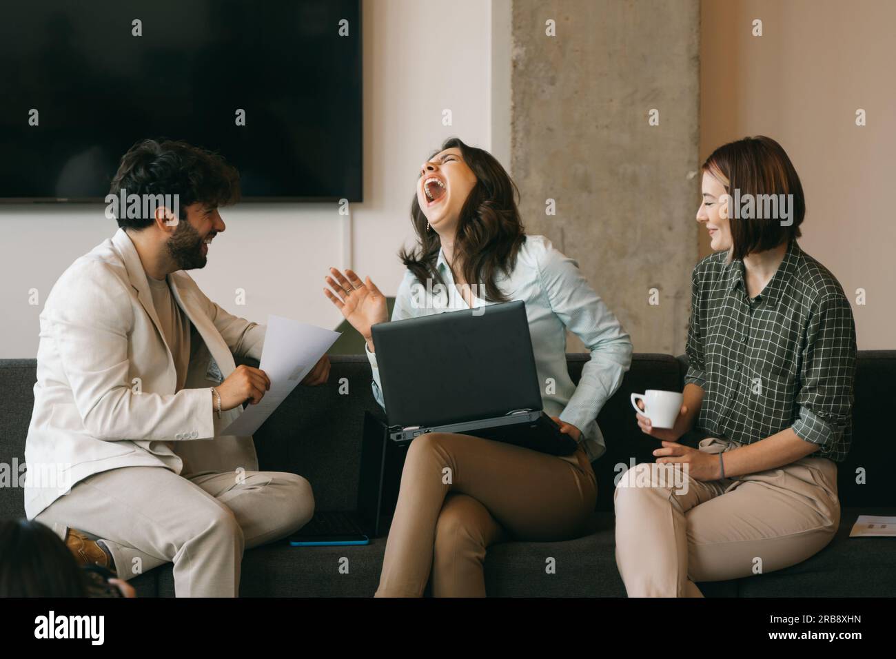Beautiful colleagues working together. Brunette girl burst out laughing after her male colleague ...