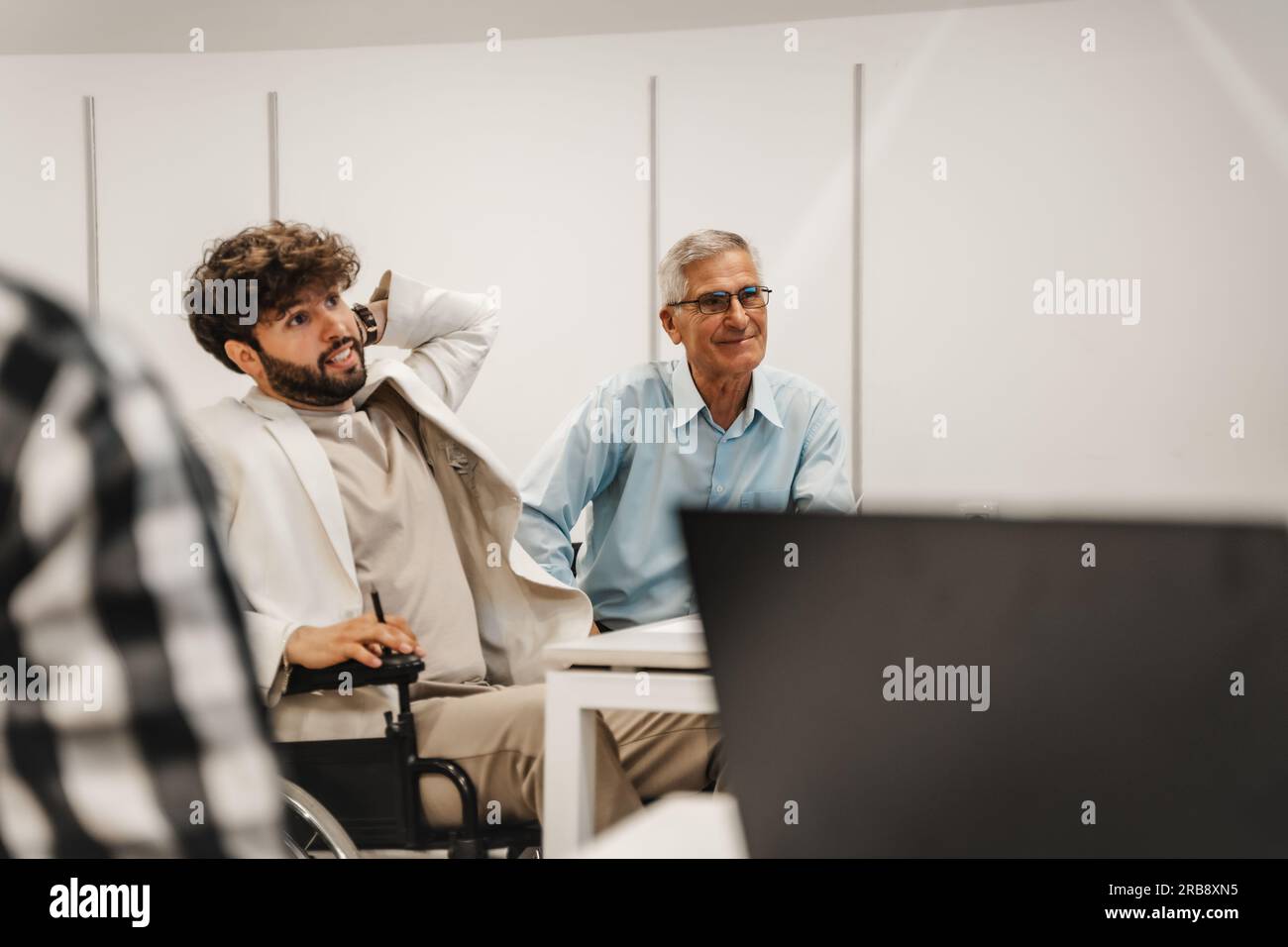 Handsome male handicapped employee in wheelchair listening to a ...