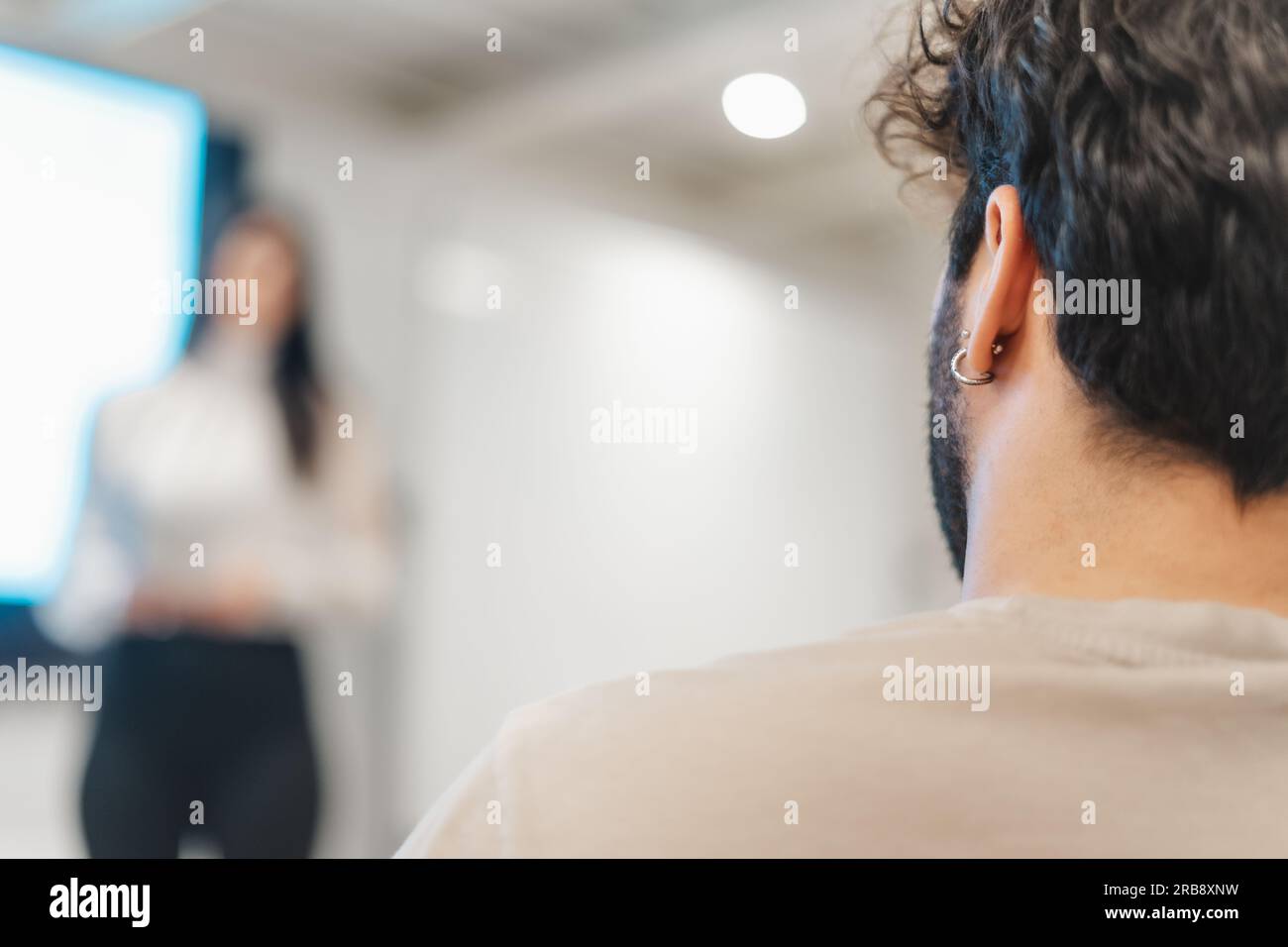 Close up photo of male person listening to a presentation. Back view ...
