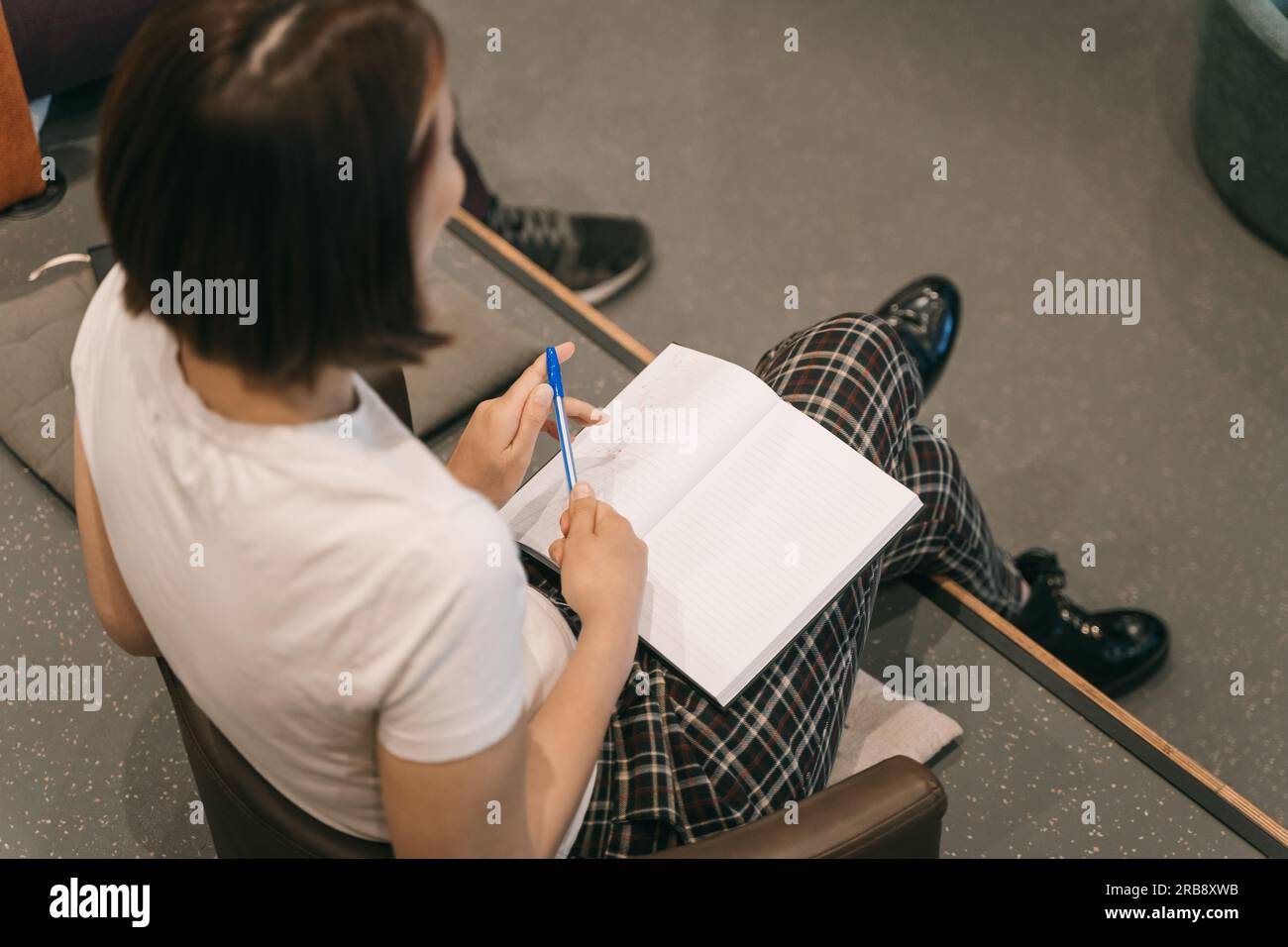 Above view photo of young female employee taking notes while being on a ...