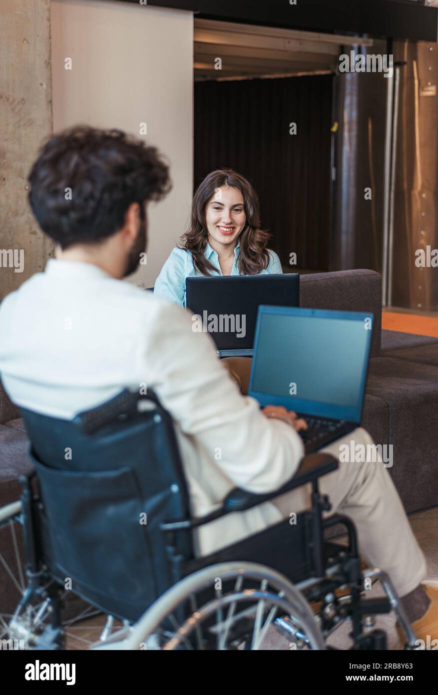 Two employees having a conversation while working together. Disabled ...