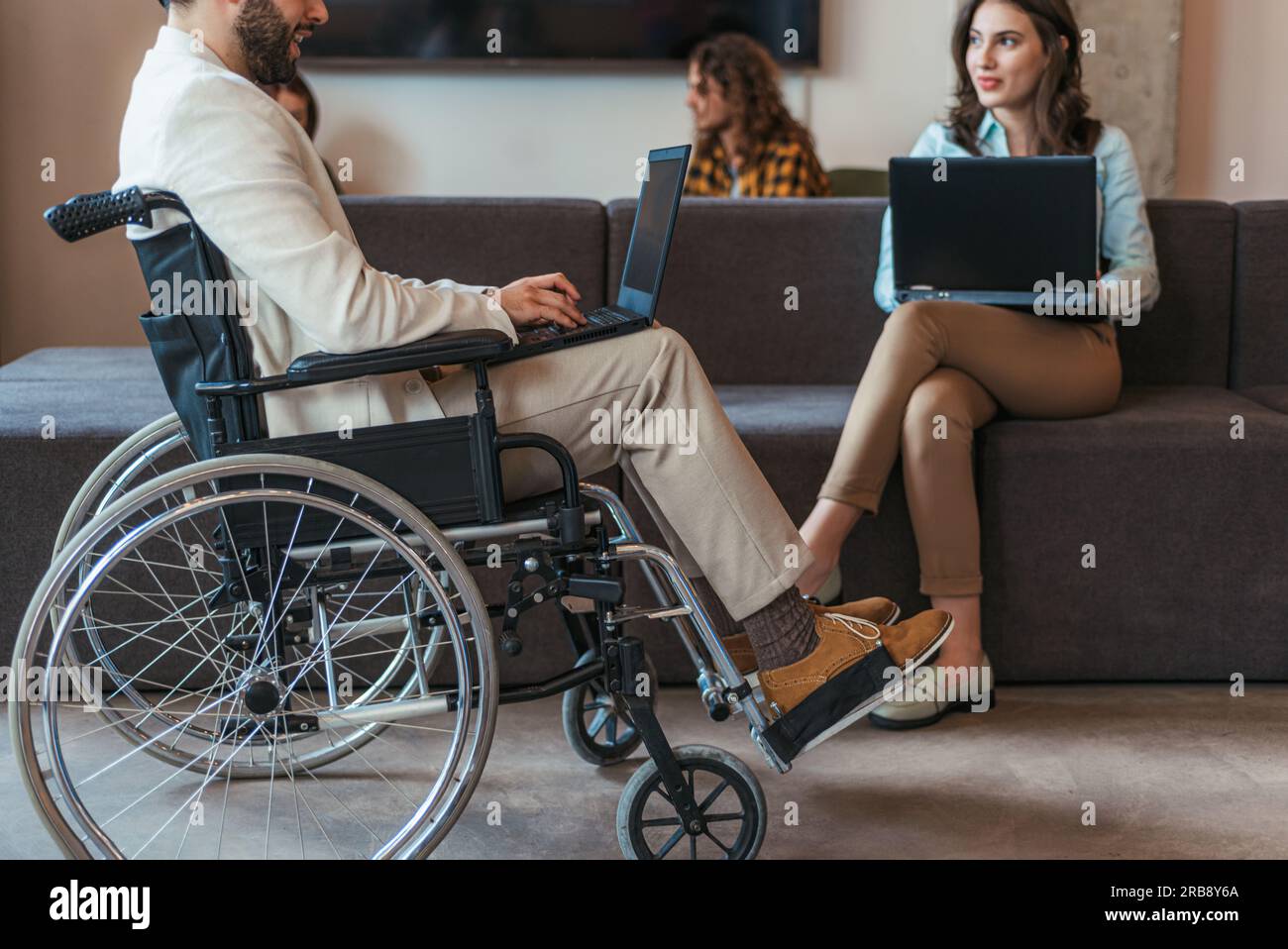 Caucasian man working on lap top in wheelchair. Side view shot Stock ...