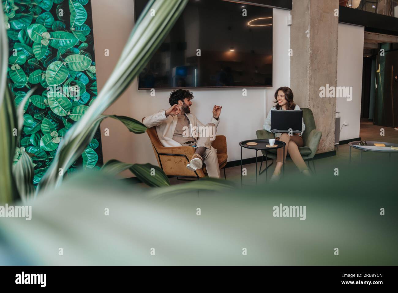 Handsome male business person explaining fun situation to his female ...