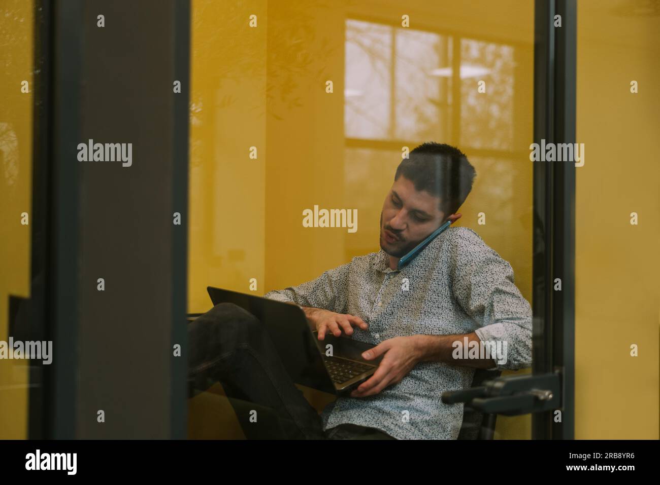 Handsome businessman having private conversation in soundproof phone ...