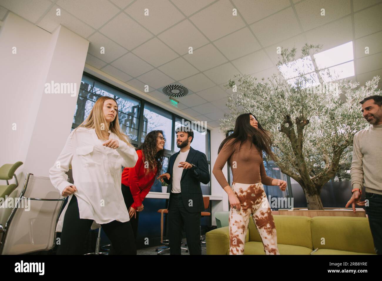 Creative international group of people dancing at the office after ...